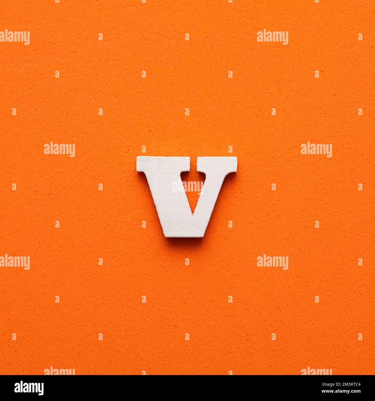 White lowercase letter v on orange foamy background Stock Photo - Alamy