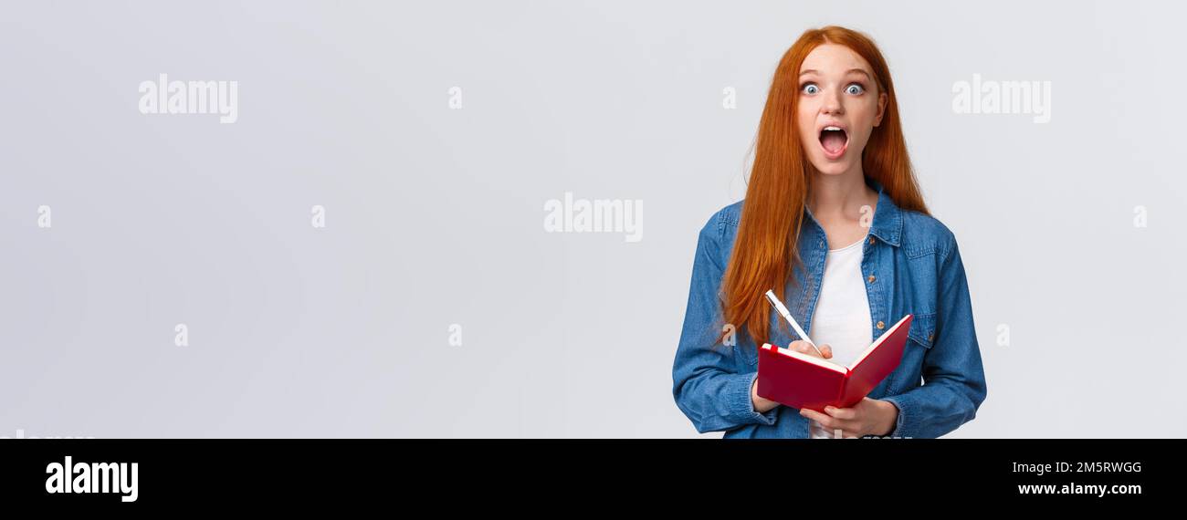 Amused and excited, astonished redhead girl fascinated with amazing ...