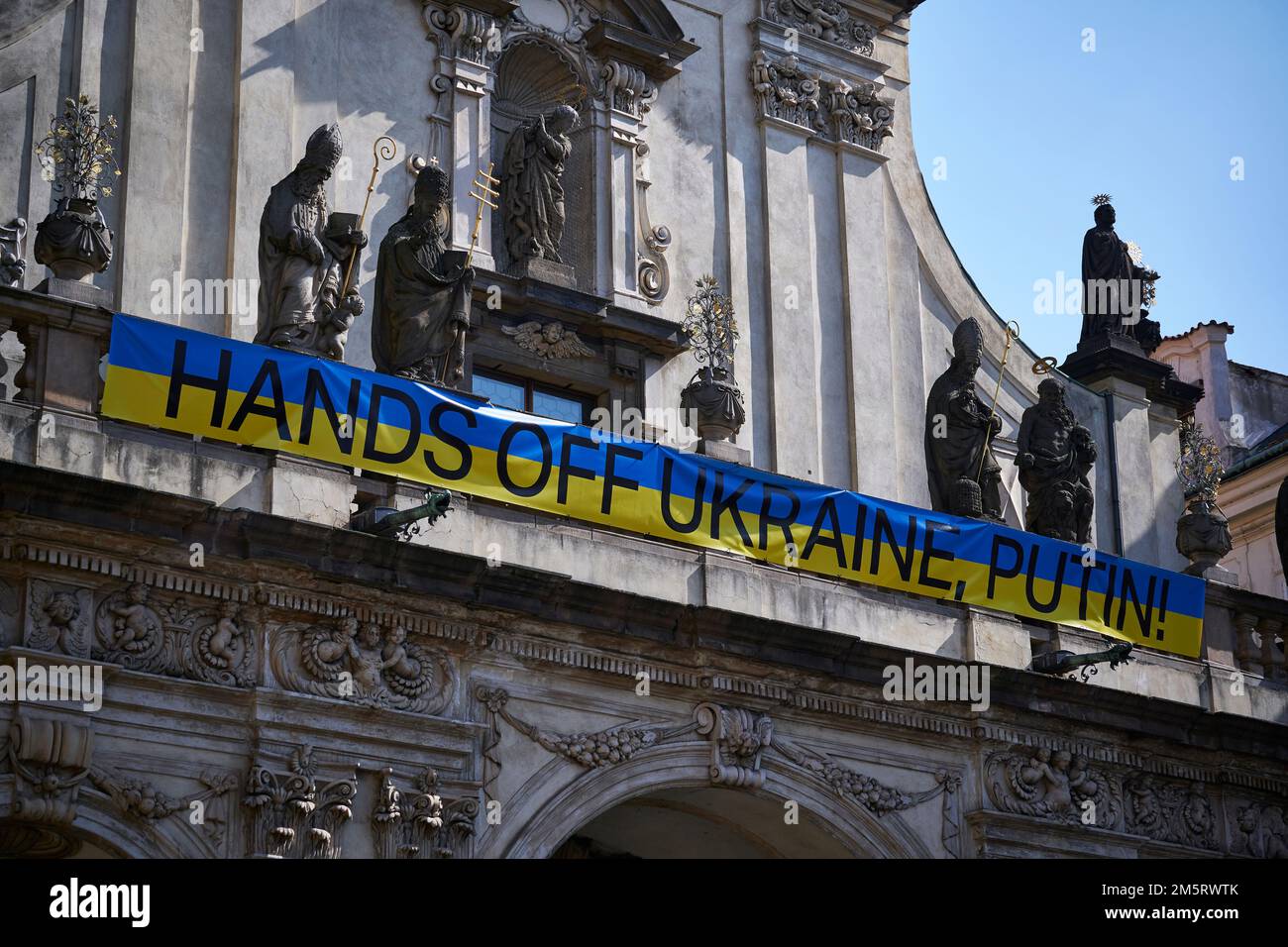 A banner on a building with Ukrainian flag colors with the text "Hands ...