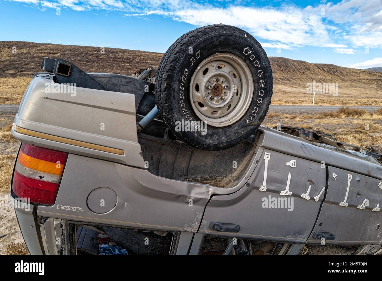 A single rear tire remains attached to a Jeep SUV that rolled over in ...