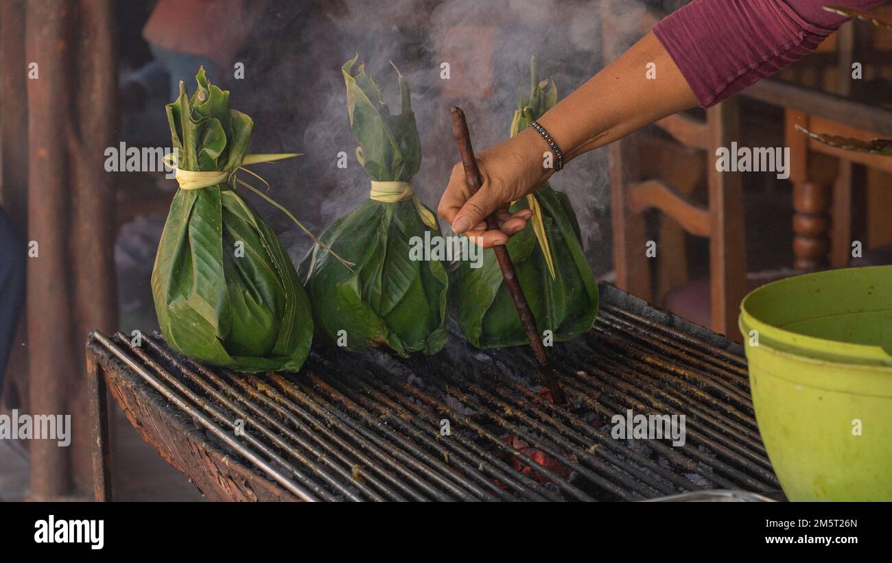 typical food of the jungle. charcoal grilled meat inside banana leaves ...