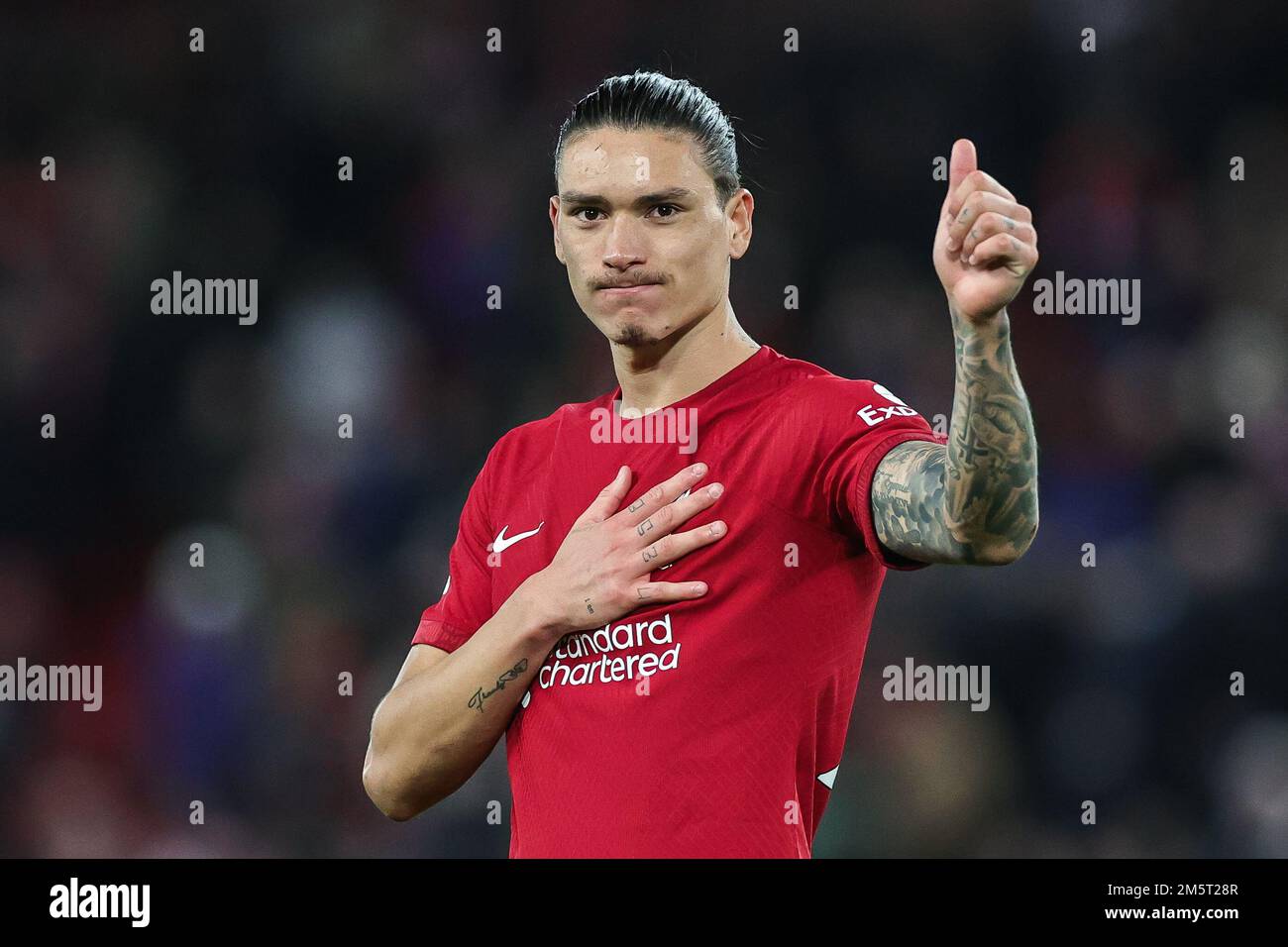 Darwin Núñez #27 of Liverpool touches the badge on his shirt and gives ...