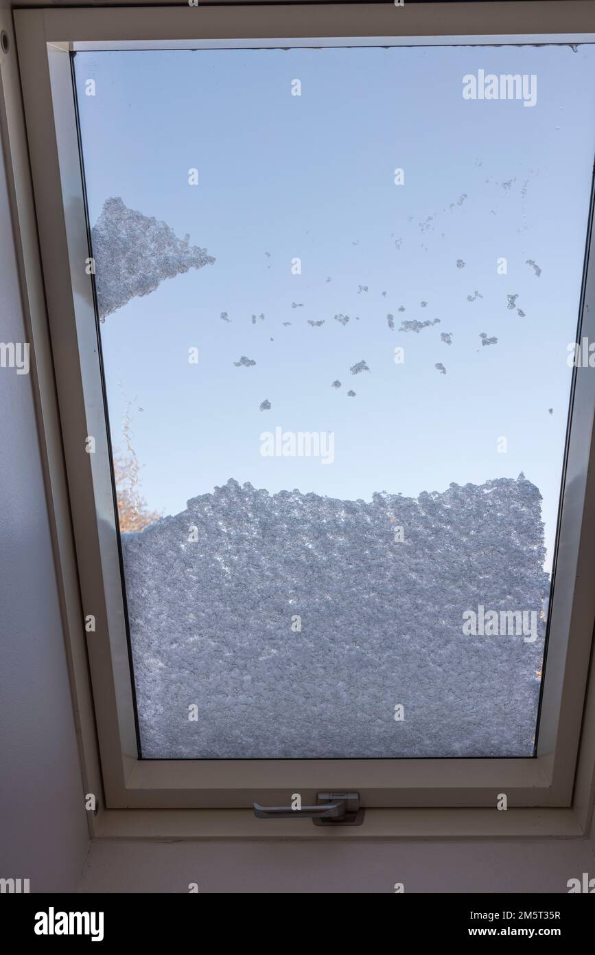 View of interior of snow-covered dormer window on roof of house from ...