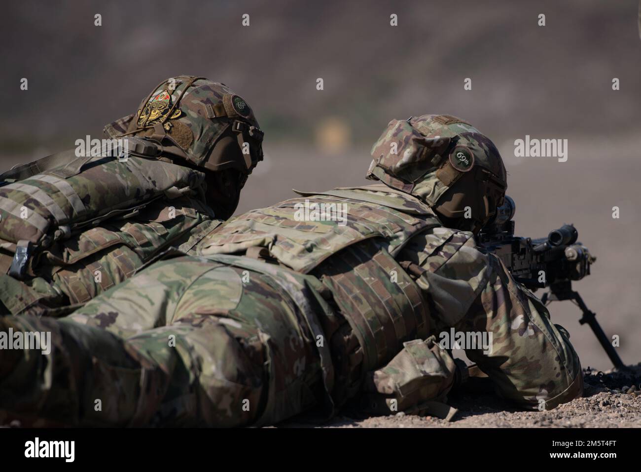 A member of Task Force Wolfhound assists a service member shooting the ...