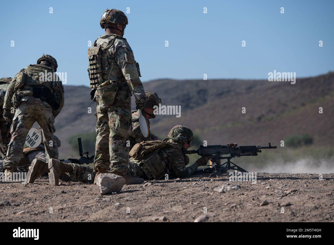 A member of Task Force Wolfhound supervises a service member shooting ...