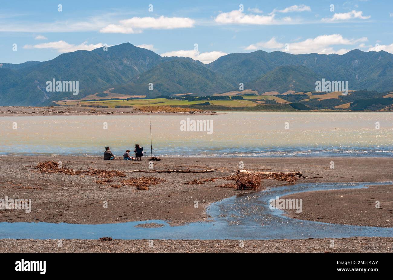 A scenic shot of people fishing at Lake Onoke with the beautiful ...