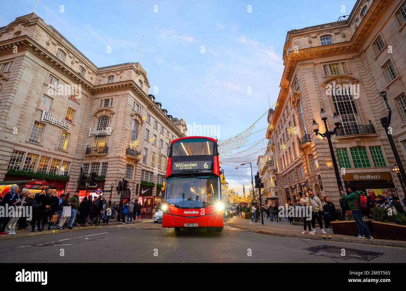 People and traffic at Piccadilly Circus in London, UK. This is an evening view south from ...