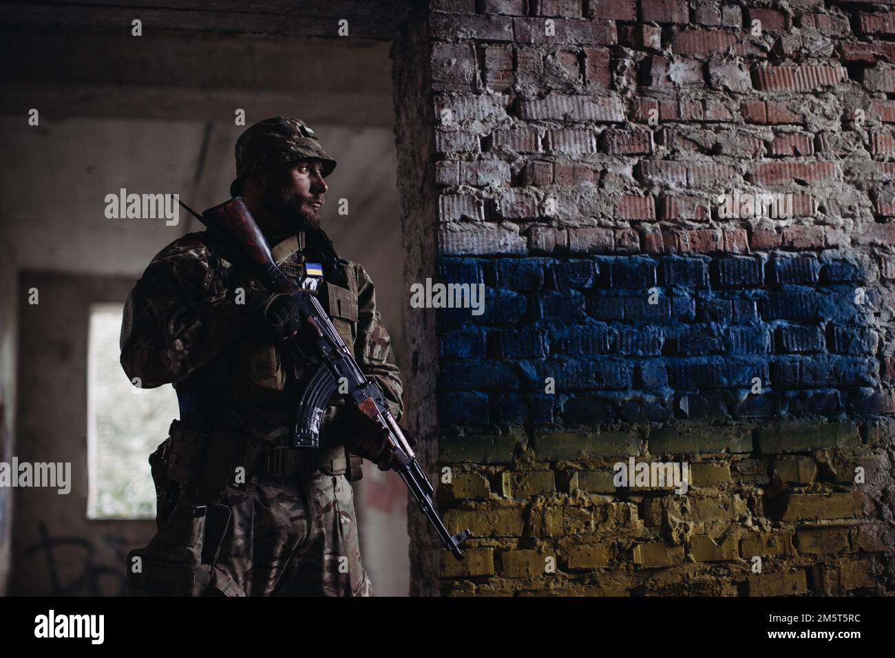 A Ukrainian military man with a weapon in his hands stands against the ...