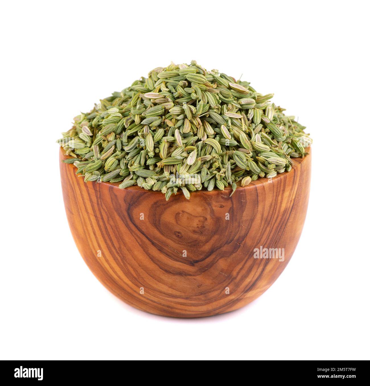 Fennel seeds in wooden bowl, isolated on white background. Green fennel ...