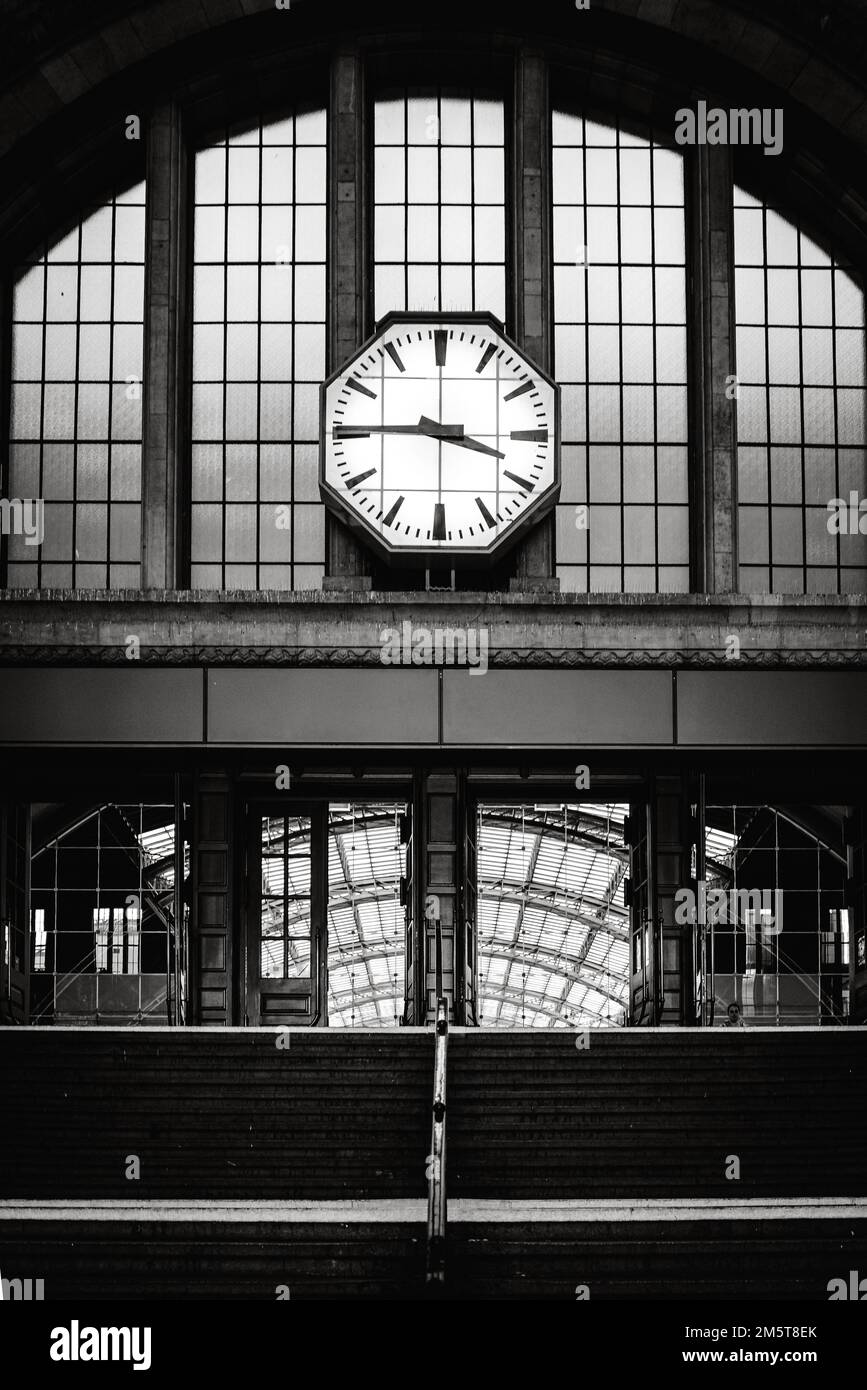 An old clock hanging from a wall in a railway station in Cologne ...