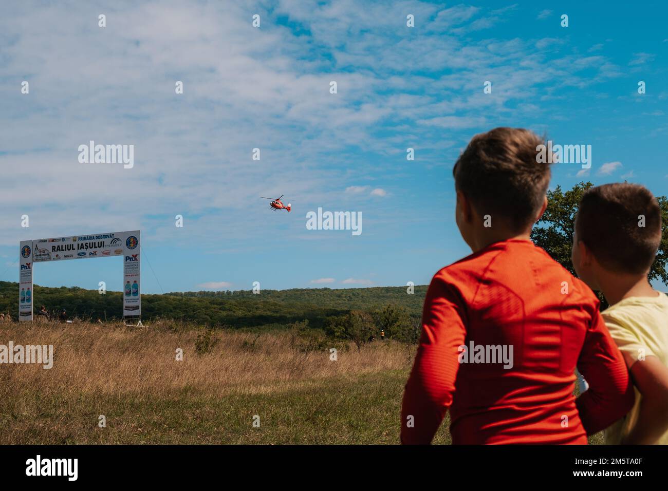 two boys watching a helicopter fly at Iasi Rally 2022, during a ...