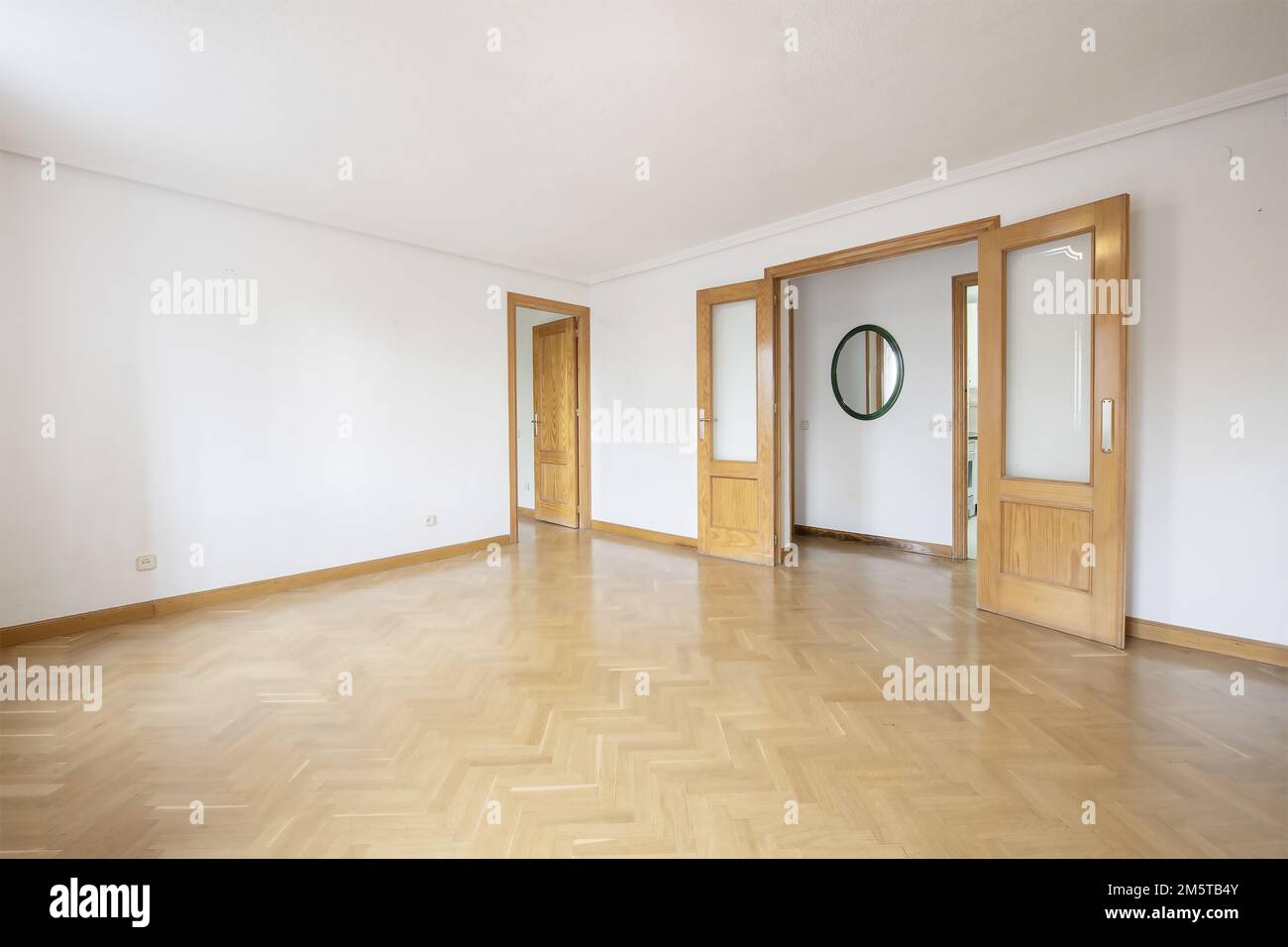 Empty living room with double oak doors with glass cabinets and access ...
