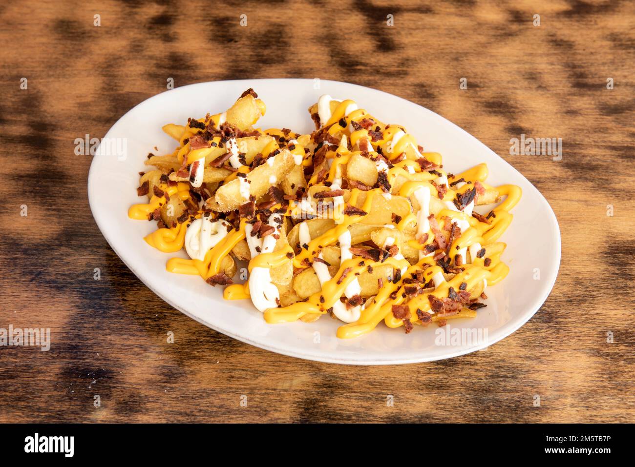A white china tray with a large serving of French fries topped with ...