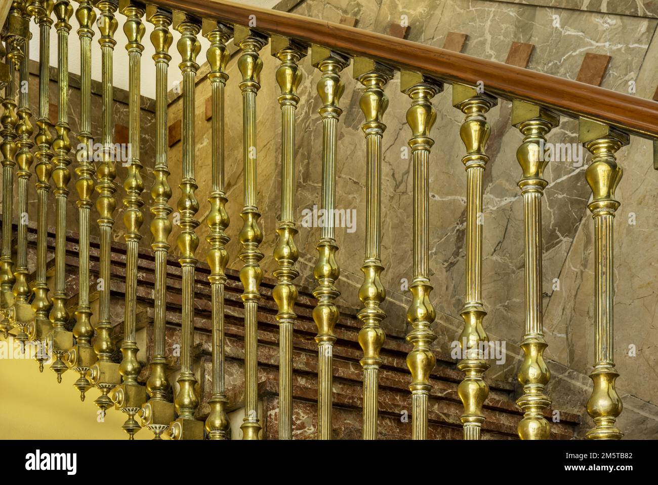 Golden metal railings on a marble staircase of an old stately building ...