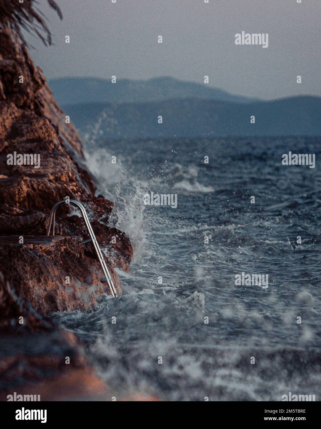 A vertical footage of a sea waves bumping into rocks Stock Photo - Alamy