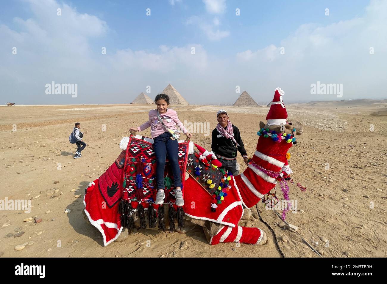 Cairo, Egypt. 30th Dec, 2022. A tourist poses for photos with a camel ...