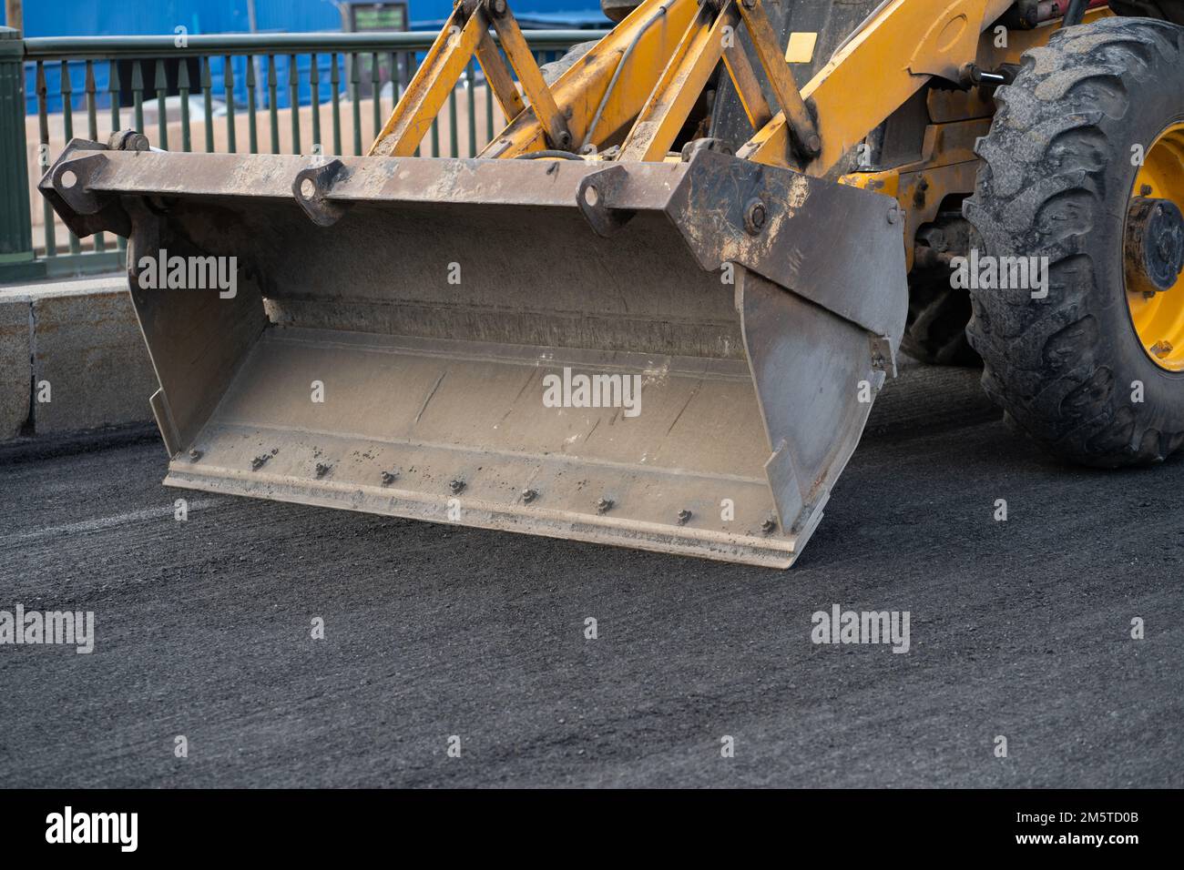 Repairing motor road with excavator with empty bucket driving on ground ...