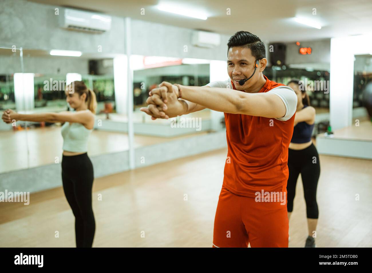 male instructor leading exercise with hand muscle stretching movements ...