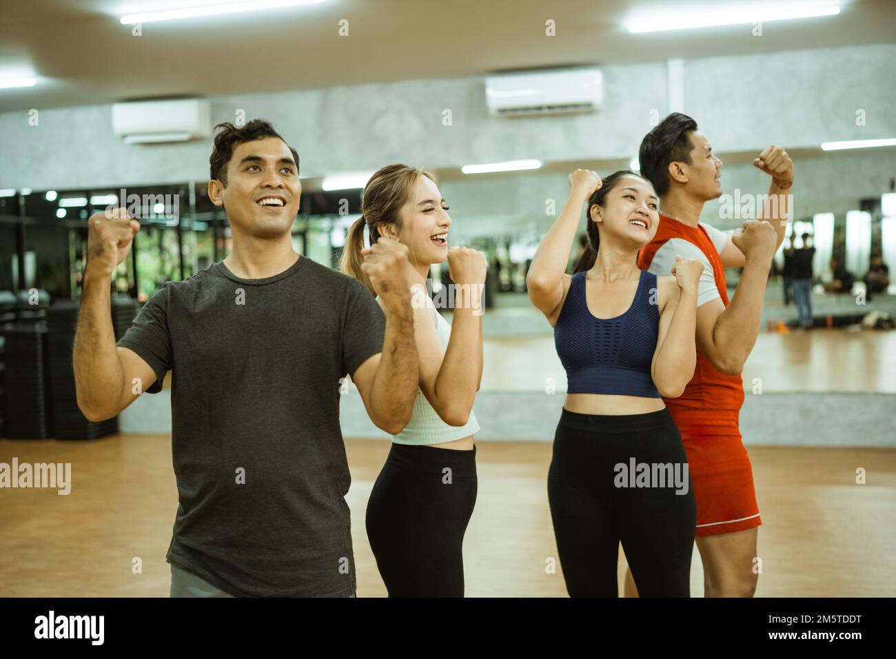 Sporty group of friends celebrating success in fitness gym Stock Photo ...