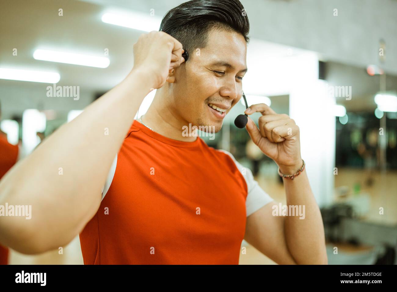 close up of instructor setting up wireless microphone before workout ...