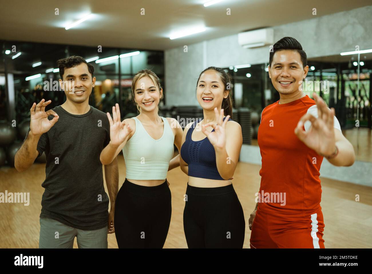 Group of diverse young friends standing with okay hand gestures Stock ...