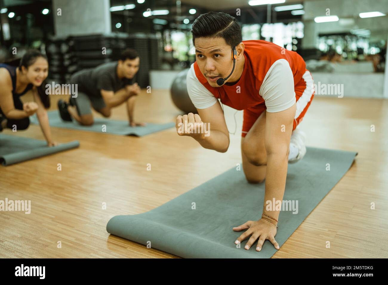 male instructor giving examples of movements to train the abdominal ...