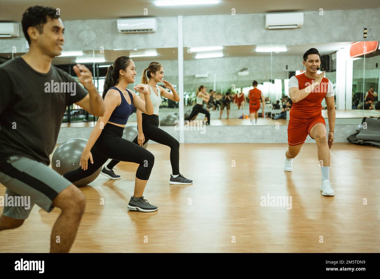four sporty people stance while exercising together Stock Photo - Alamy