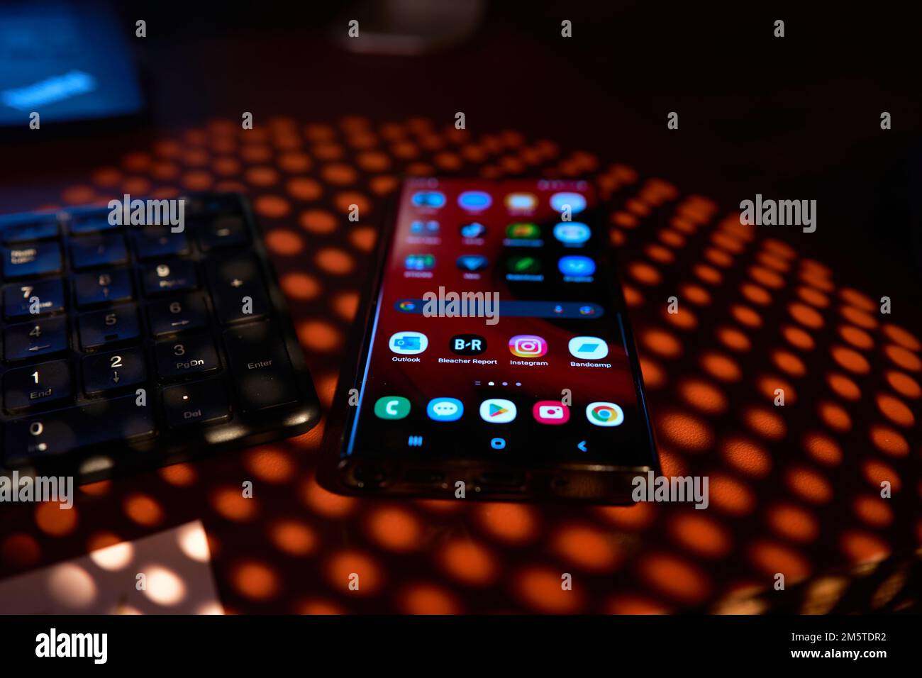 Cell Phone with bright apps showing on table shadow on Stock Photo - Alamy