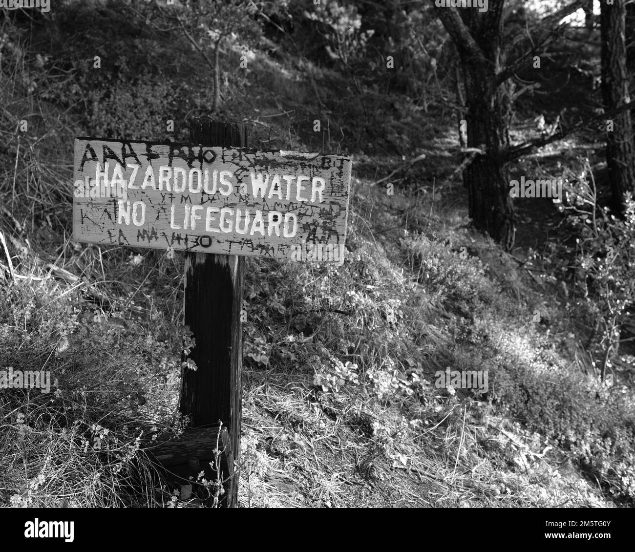 Wooden Hazardous Water No Lifeguard warning sign on trail towards ...