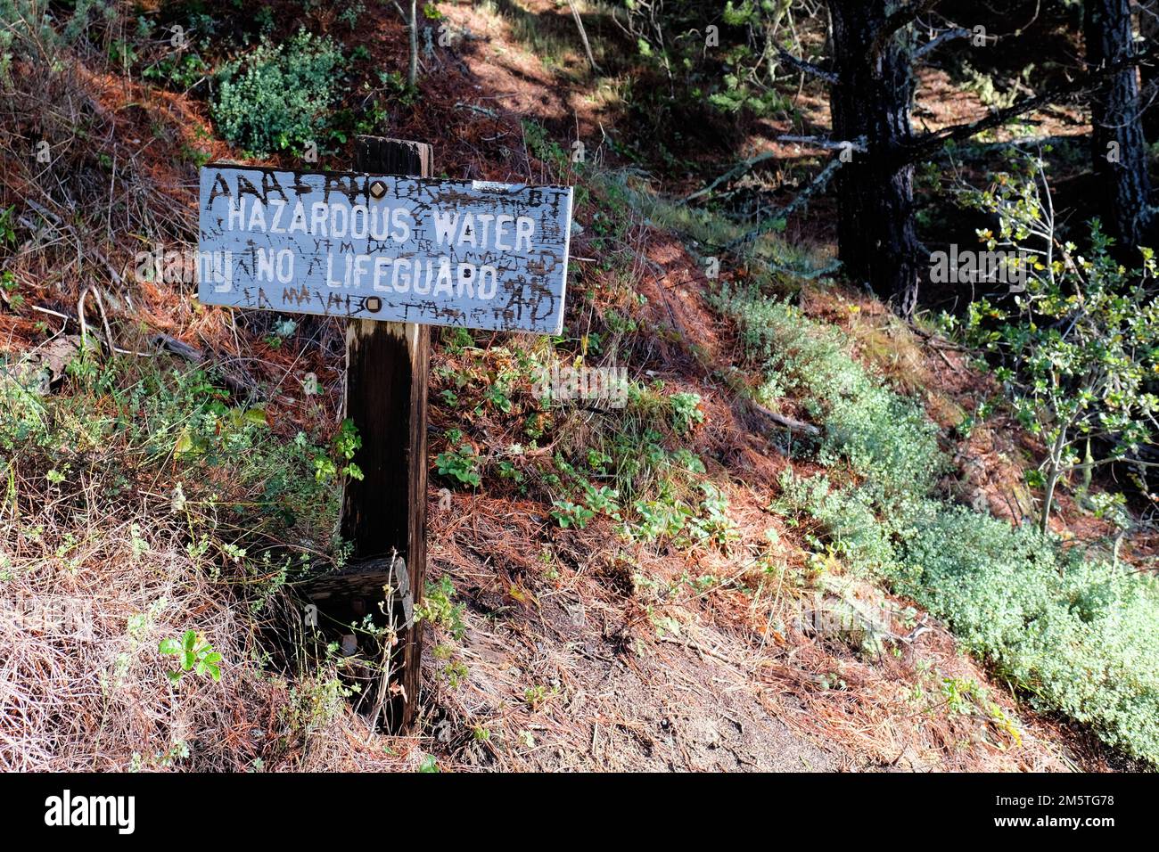 Wooden Hazardous Water No Lifeguard warning sign on trail towards ...