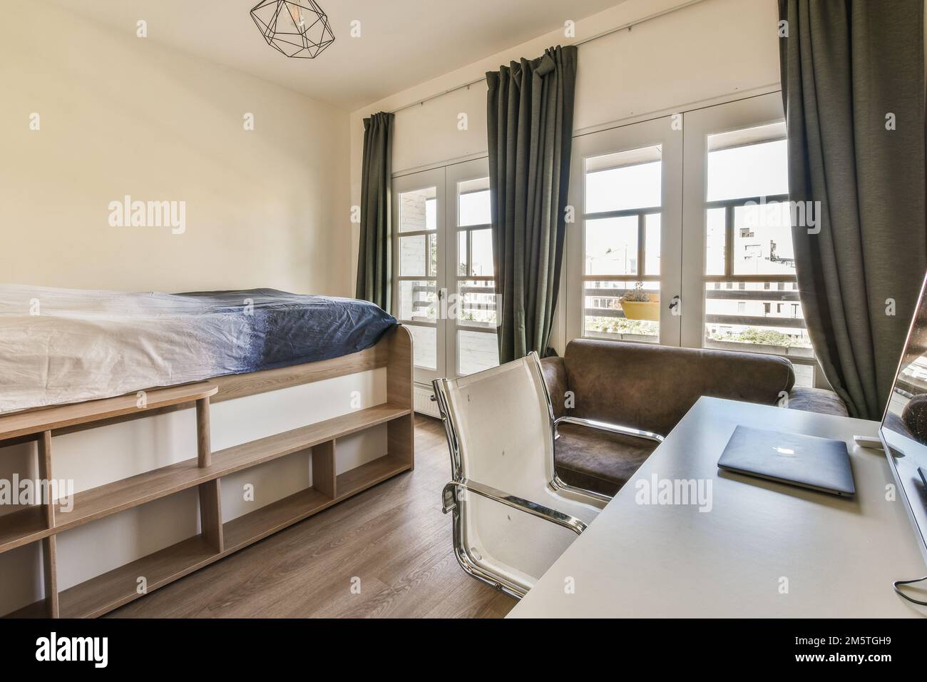 a bedroom with a bed, desk and chair in front of the window that looks ...