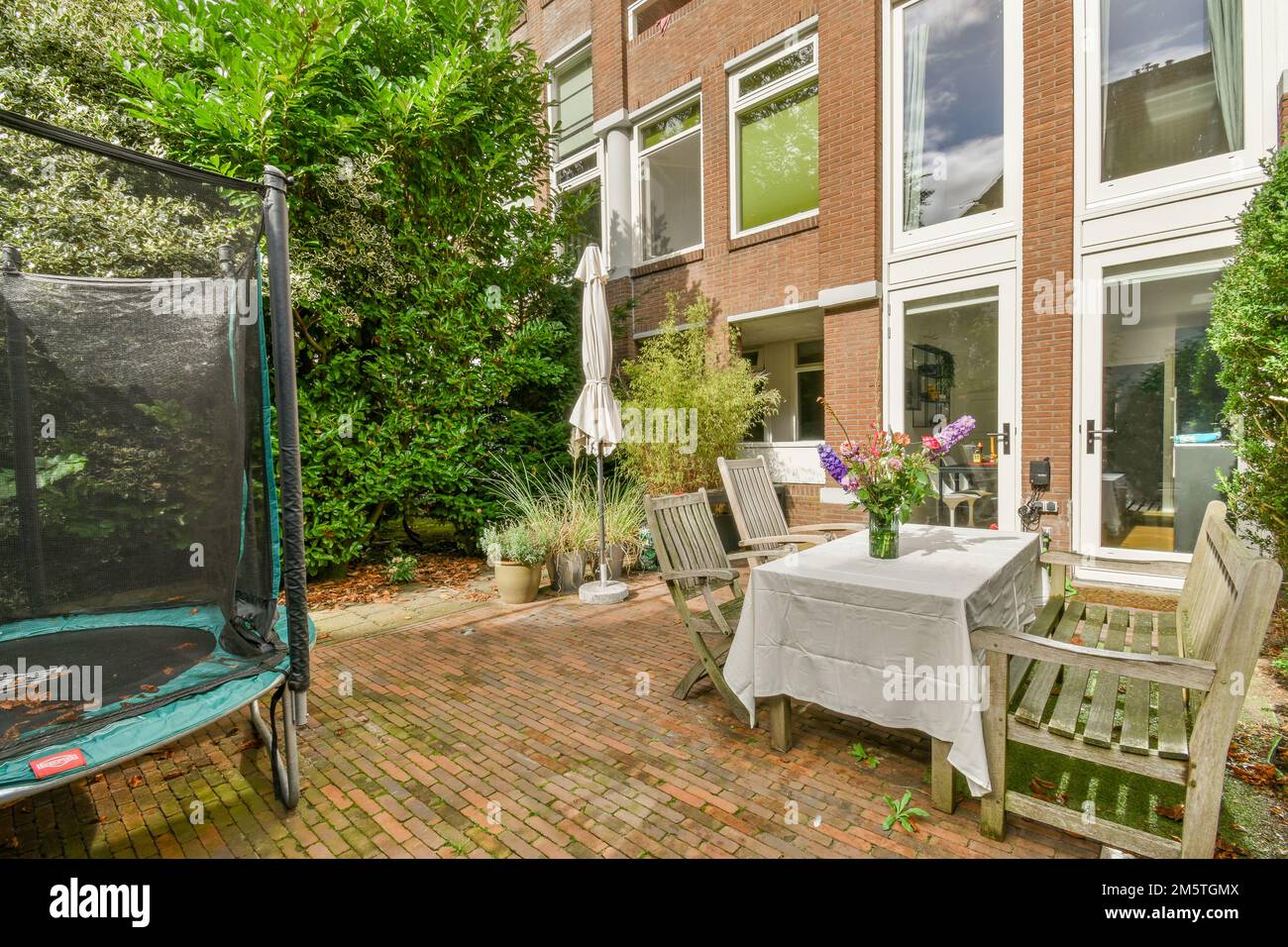 a patio with chairs, table and an umbrella on it's side door to the ...