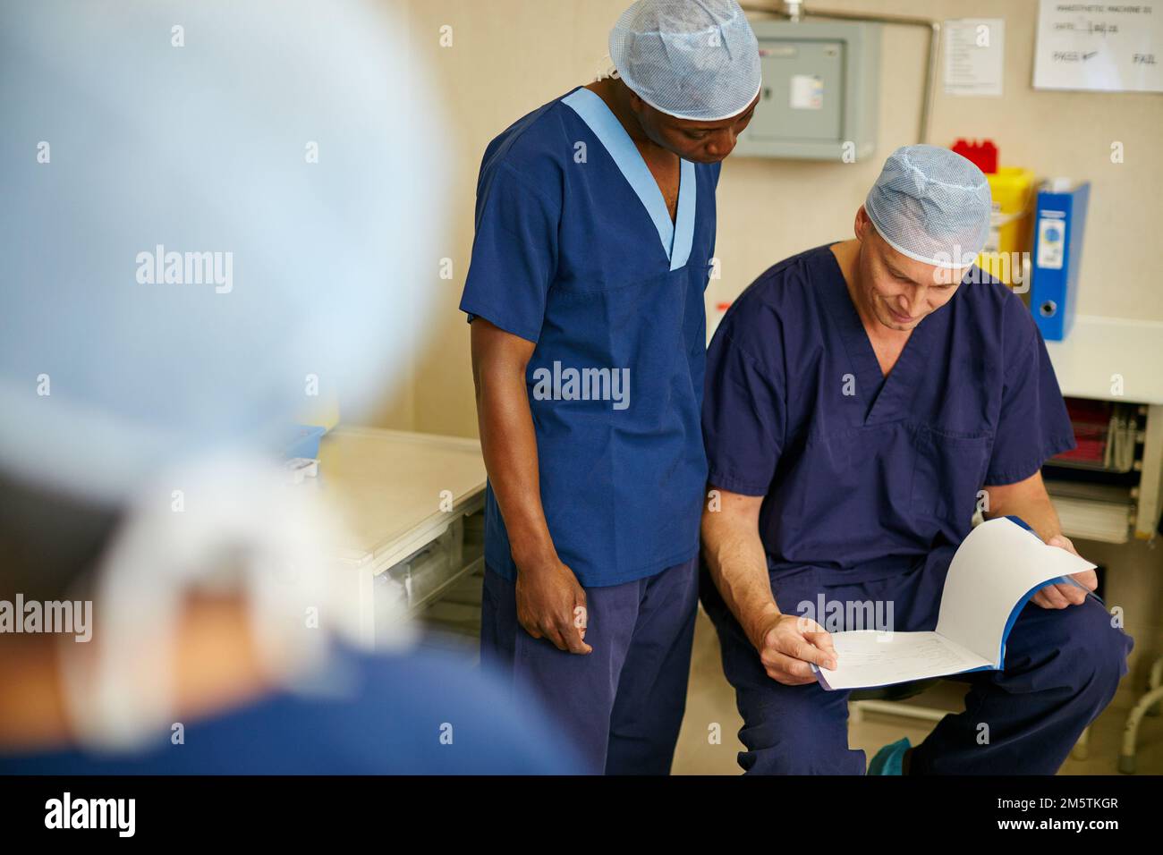 Double checking the patients stats before the operation. surgeons going through paperwork in ...