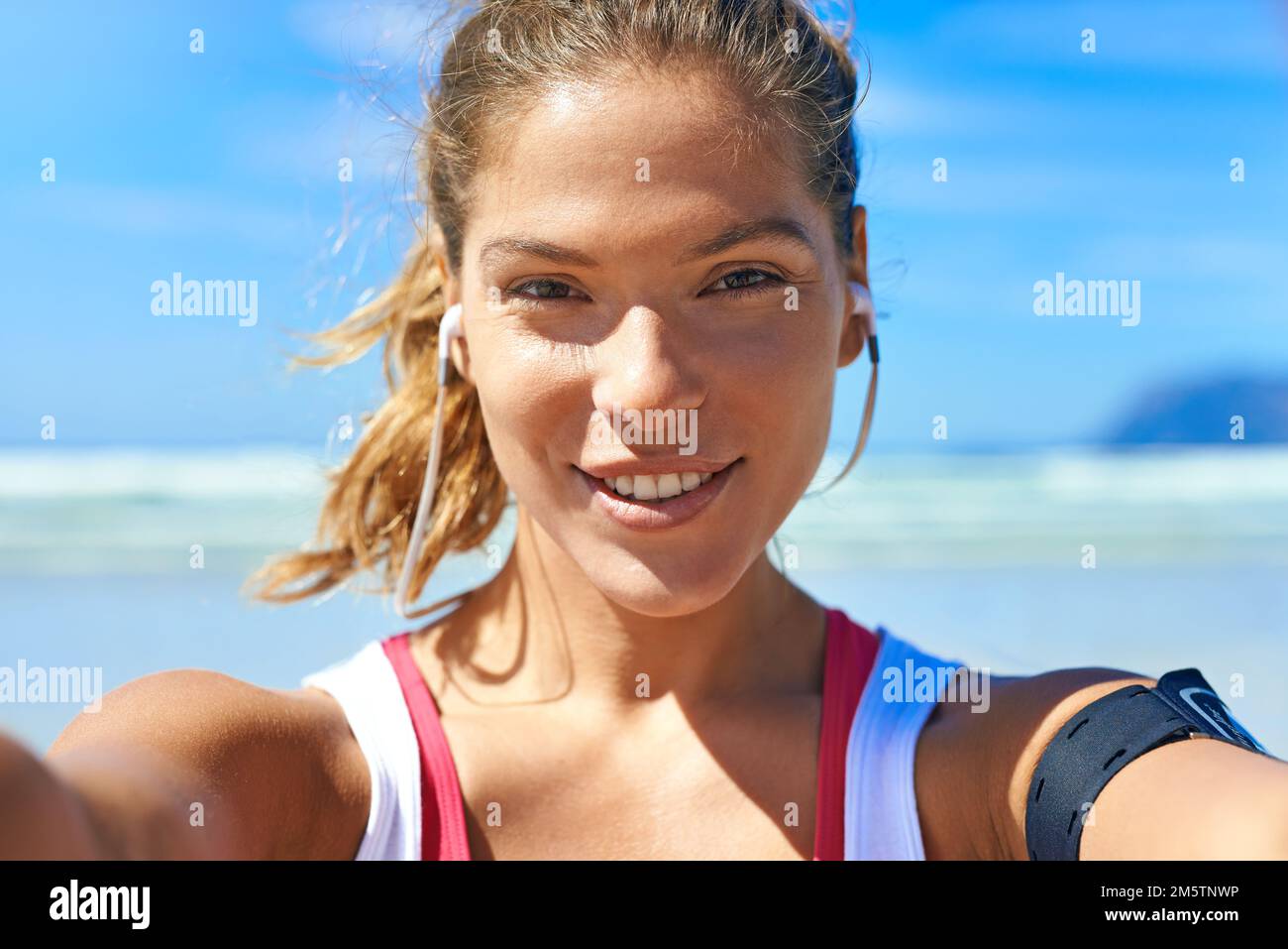 Witness the fitness. a young woman taking a selfie while working out on ...