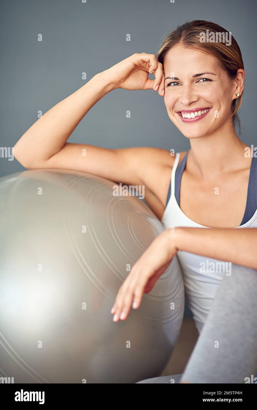 Be a baller. a sporty young woman sitting next to her fitness ball ...