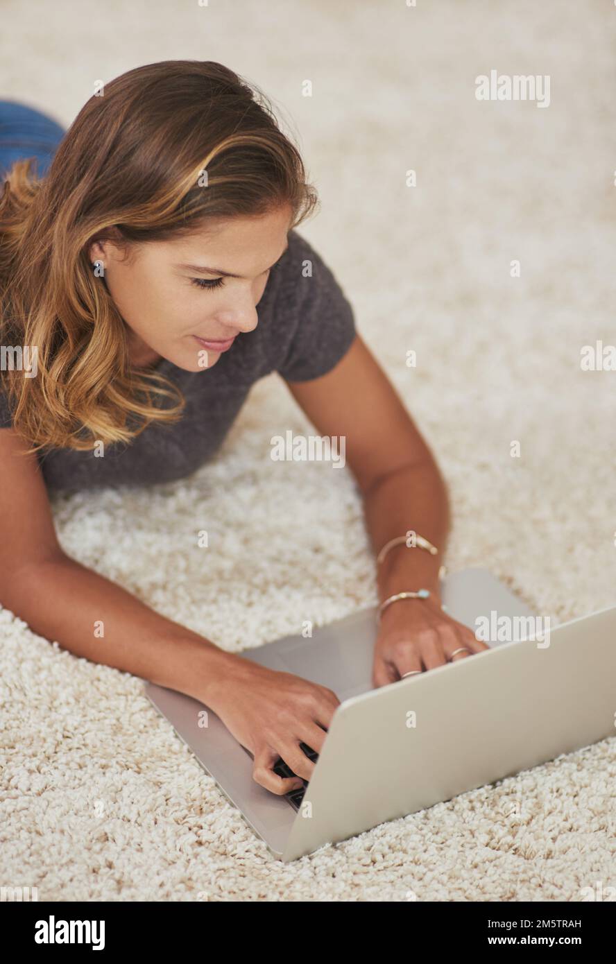 Staying social from the comfort of home. a young woman relaxing at home ...