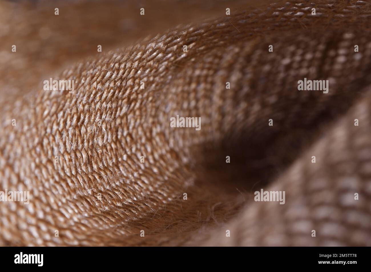 A close-up view of looking inside a curled up brown piece of Hessian ...
