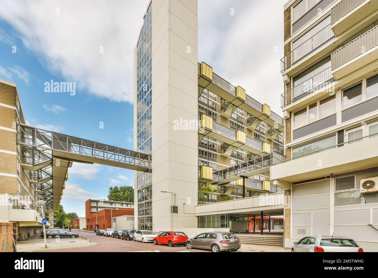 a city street with cars parked on the side and buildings in the back ...