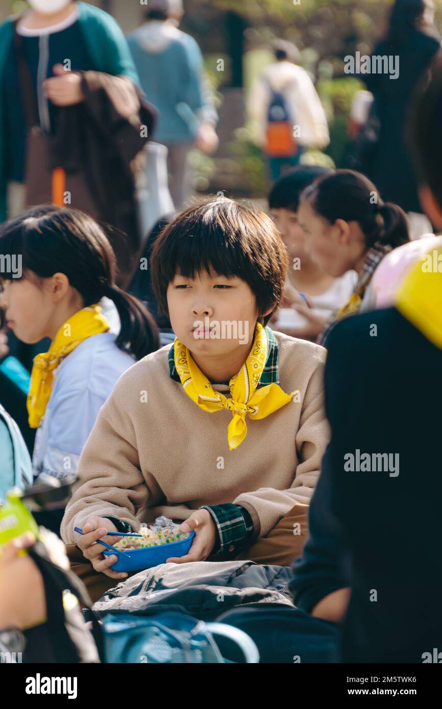 Elementary school students taking a break while on a trip to Sensoji ...