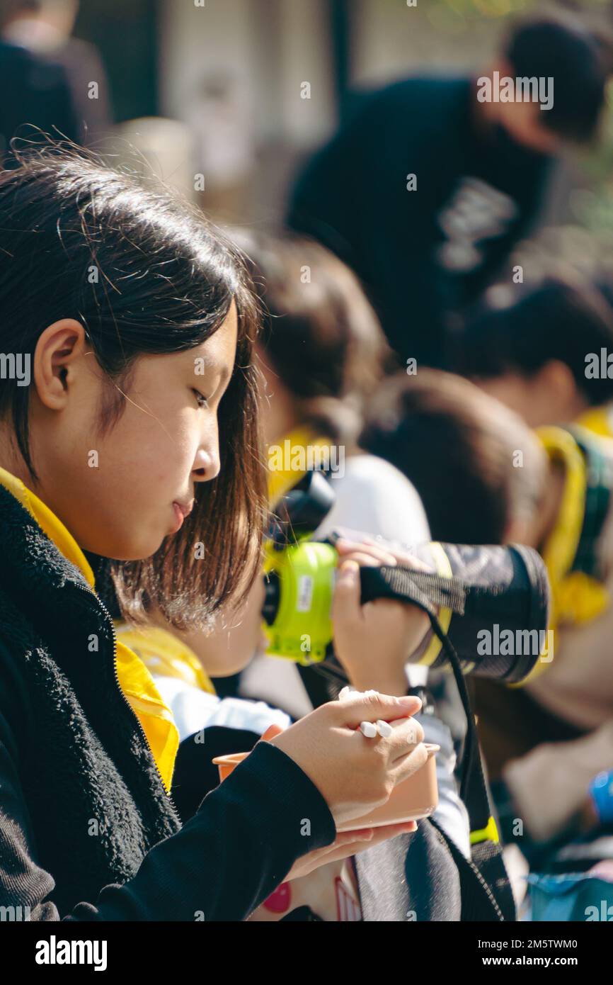 Elementary school students taking a break while on a trip to Sensoji ...