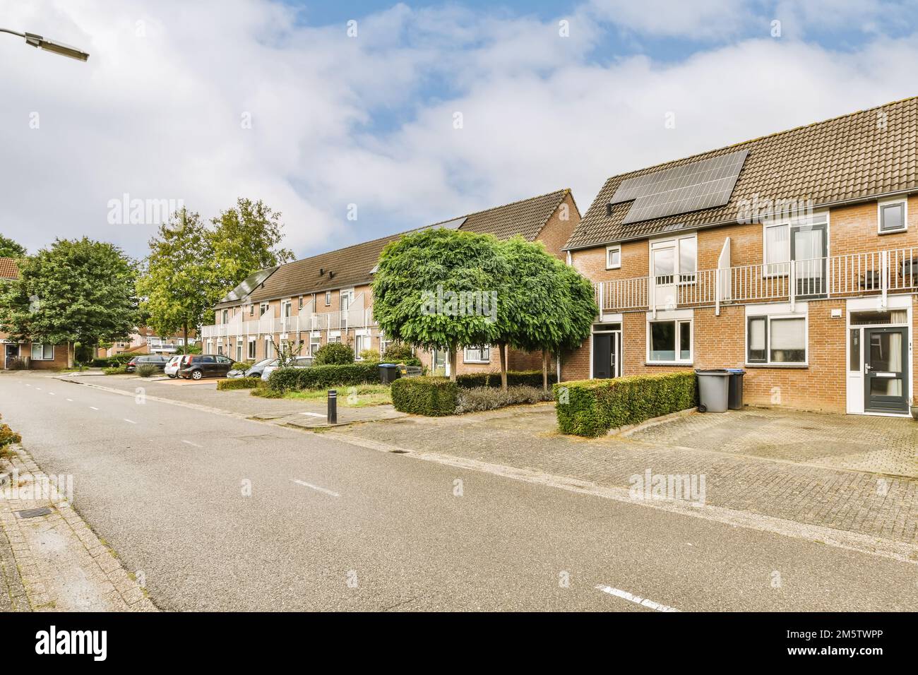 an empty street with houses in the background and blue skies overhead ...