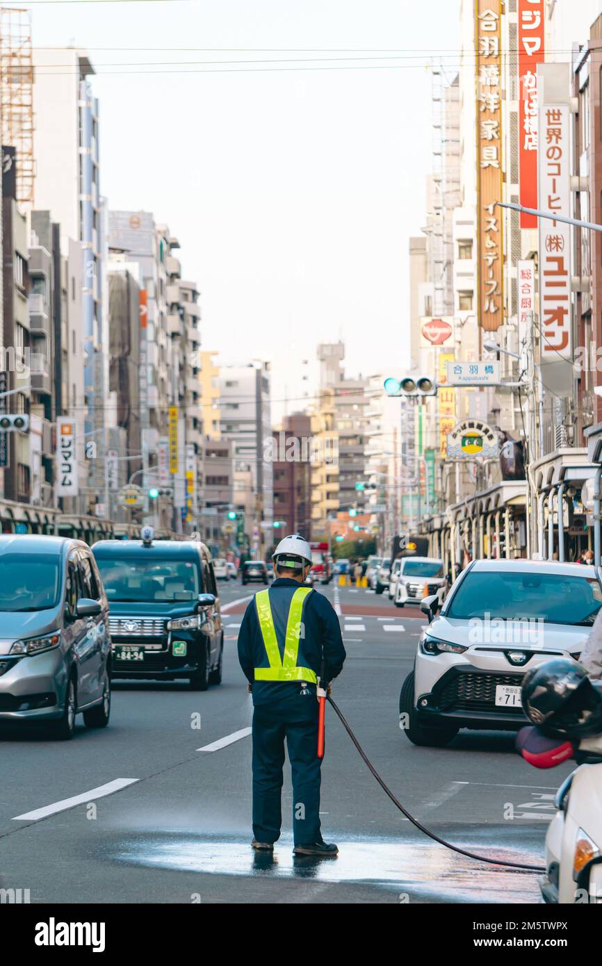 A construction worker working on the streets of downtown Tokyo Stock ...