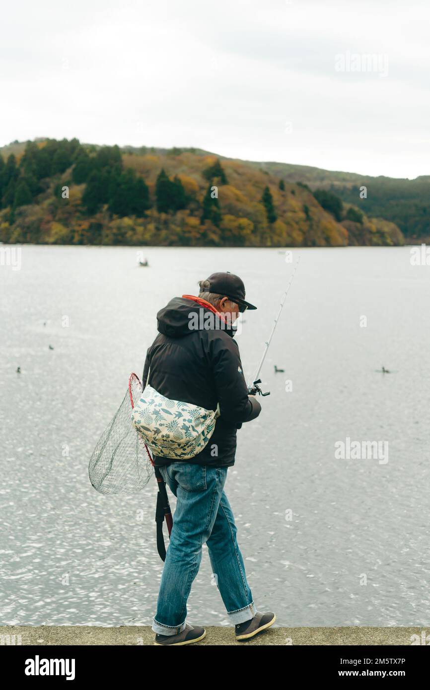Old man fishing by lake Ashi, Hakone Stock Photo - Alamy