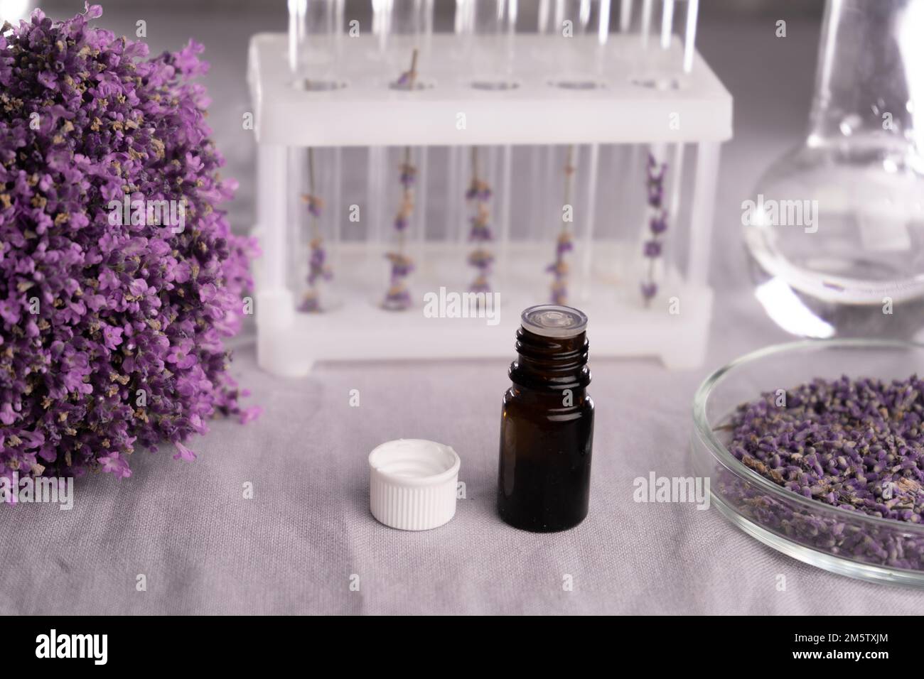 Laboratory oil bottle with essential lavender oil, flowers and ...