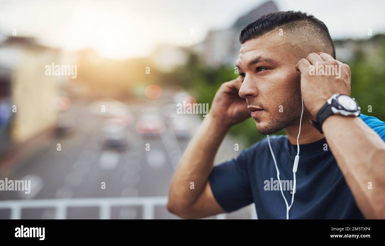 Getting psyched before his run. a young man out for a run in the city ...