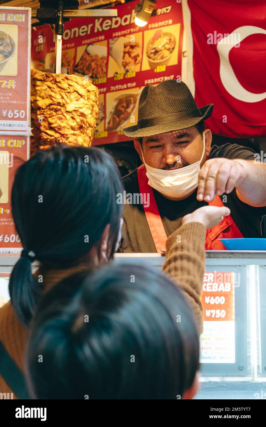 Middle eastern man serving customers in a kebab booth Stock Photo - Alamy