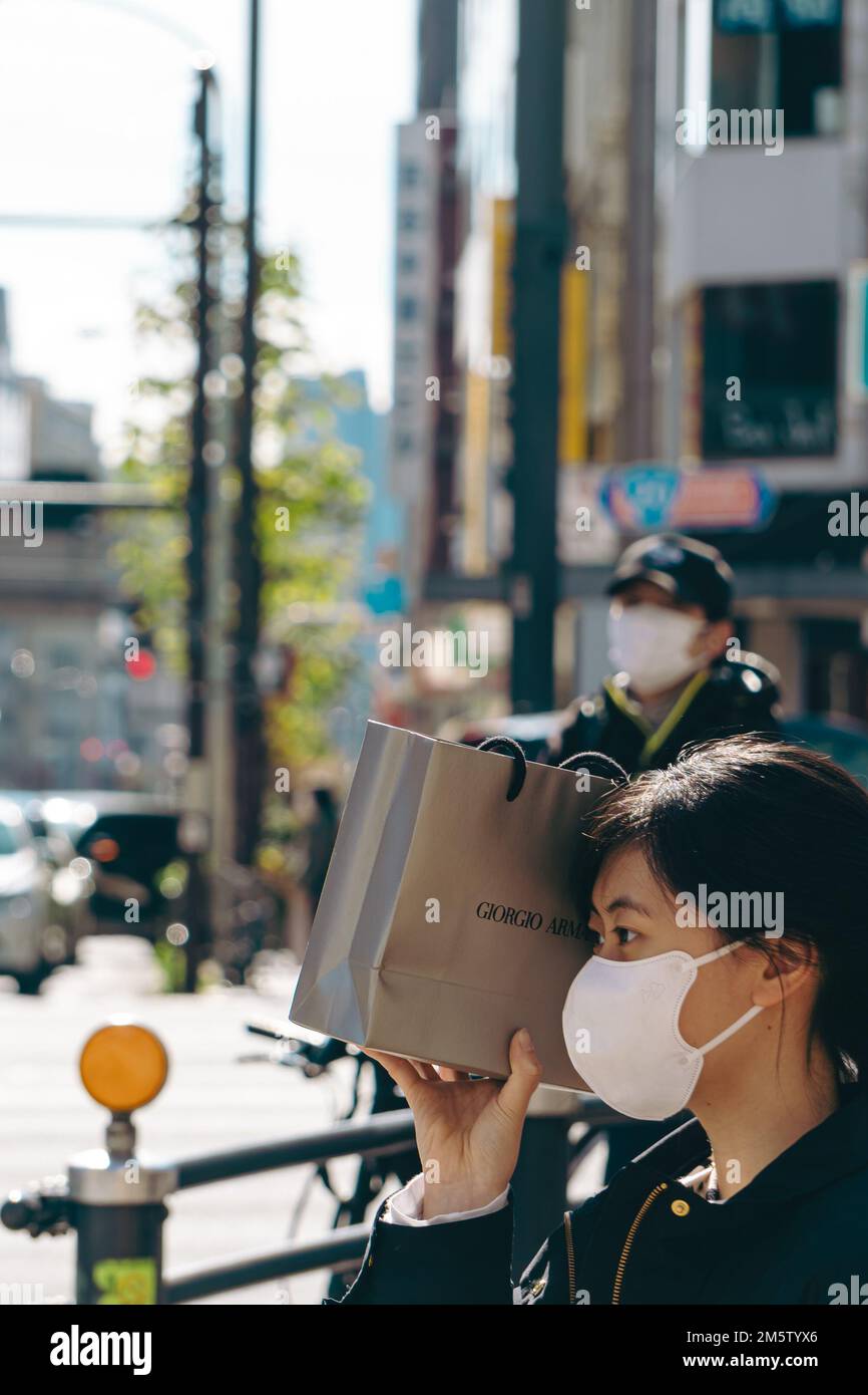 A girl covering her face with a paperbag, blocking her face from the ...