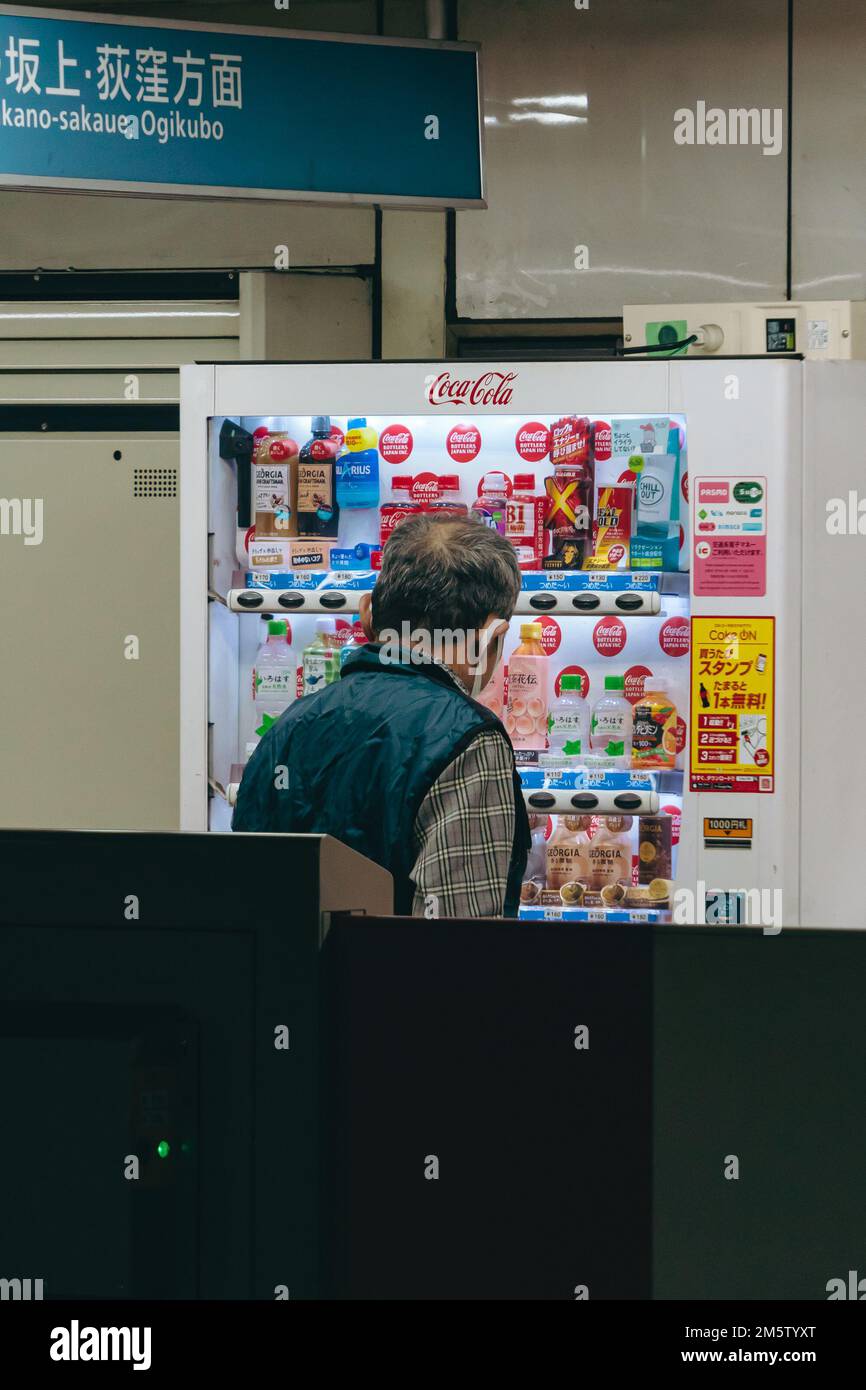 An old man trying to get refreshments from the vending machine Stock ...
