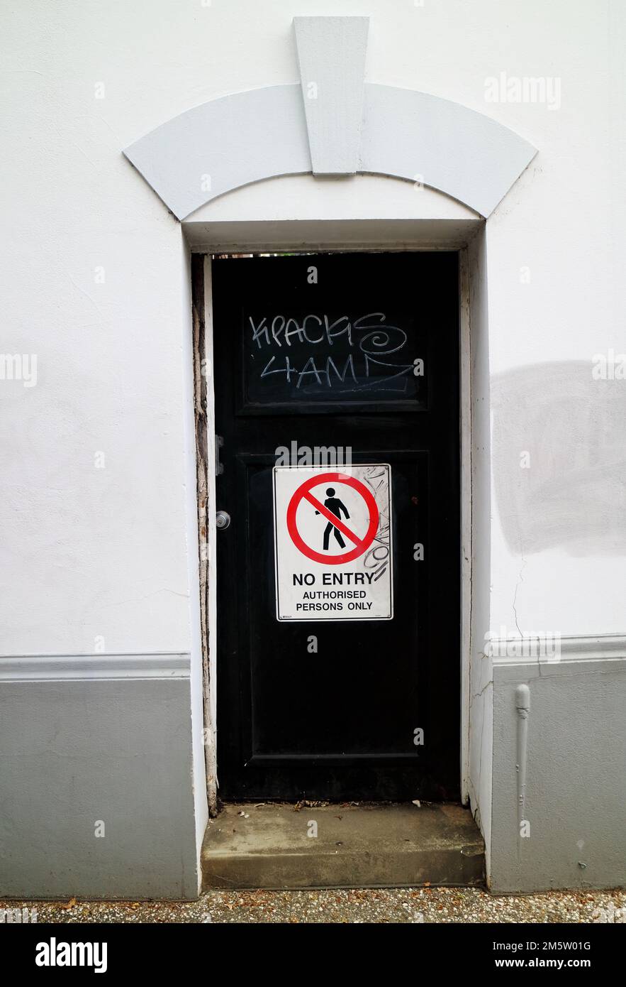No entry sign on an old black door with graffiti tags Stock Photo - Alamy