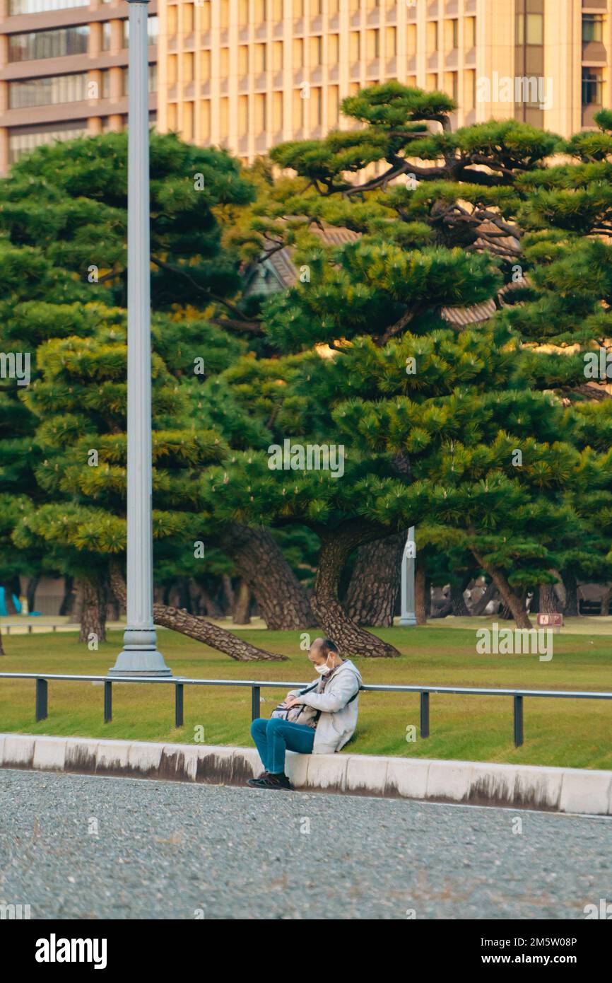 A man sitting and writing in a park Stock Photo - Alamy